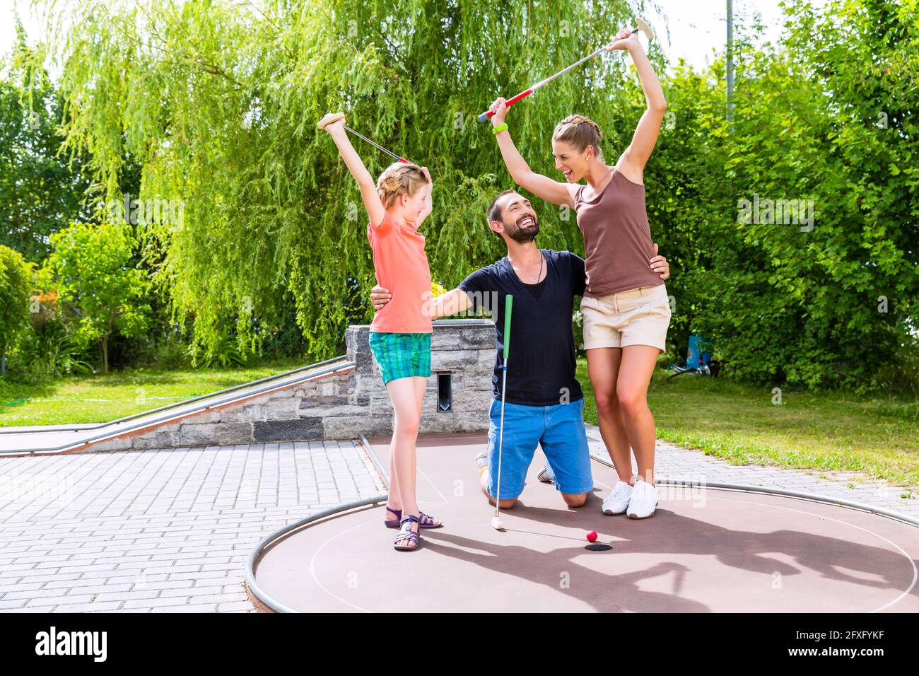 Family playing miniature golf outdoors Stock Photo - Alamy