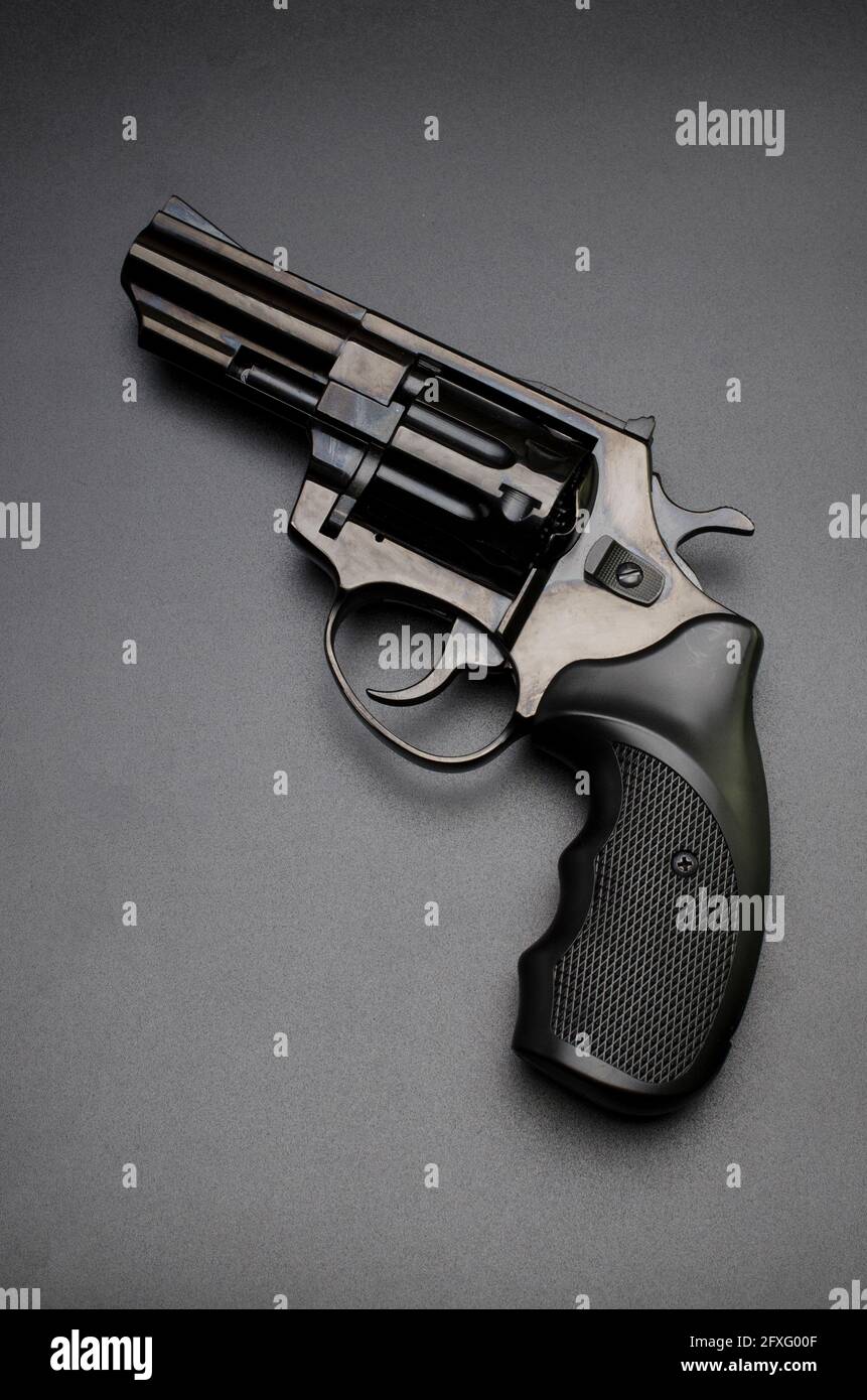 black shiny revolver on black background Stock Photo - Alamy