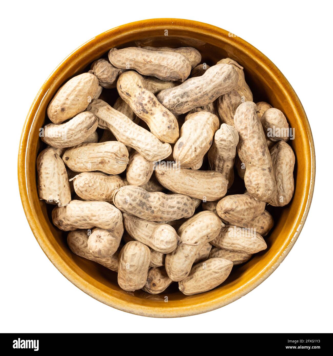 top view of unpeeled peanuts in round ceramic bowl cutout on white ...