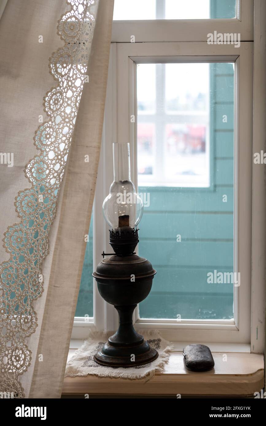 Vintage kerosene lamp and case for glasses on window sill Stock Photo ...