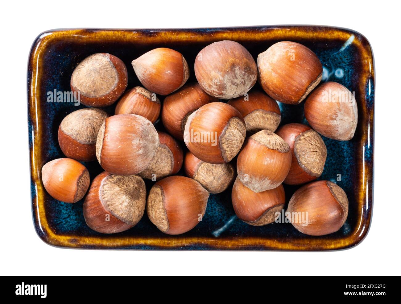 top view of unshelled hazelnuts in bowl cutout on white background ...