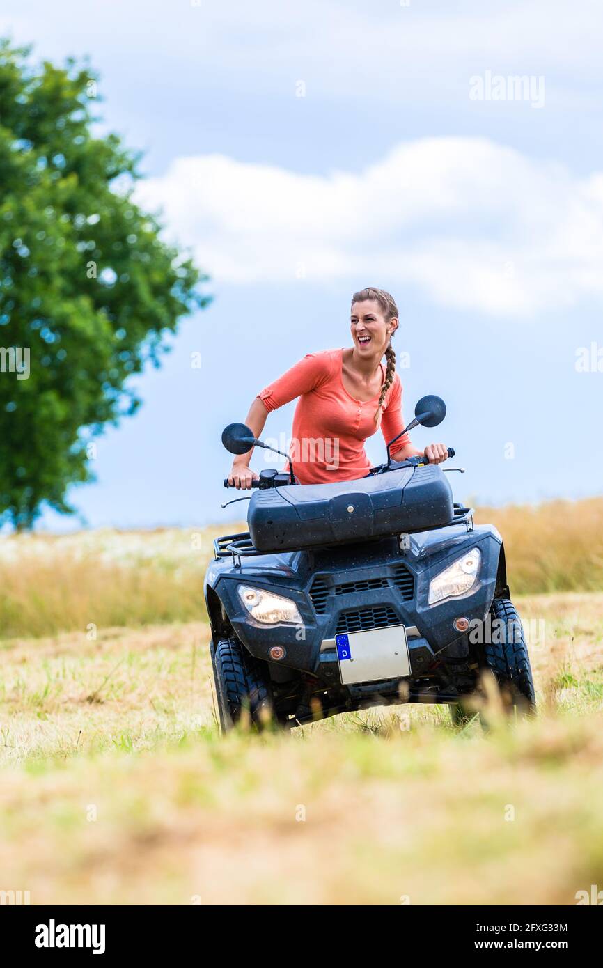 Woman driving off-road with quad bike or ATV Stock Photo - Alamy