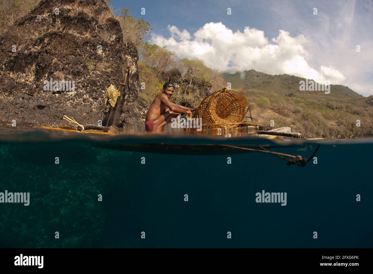 Fisherman with fish basket on fishing boat, Crucifixion Point dive site ...
