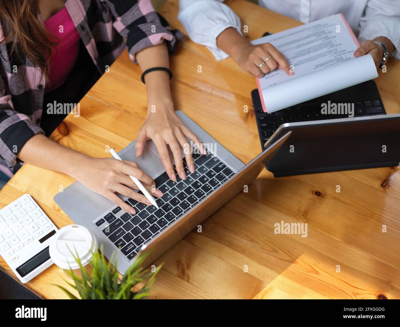 Top view of two female students brainstorming on their group assignment ...