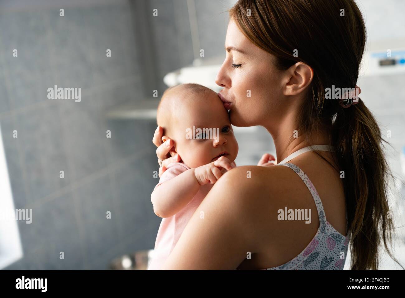 Happy mother and baby hugging and playing together Stock Photo - Alamy