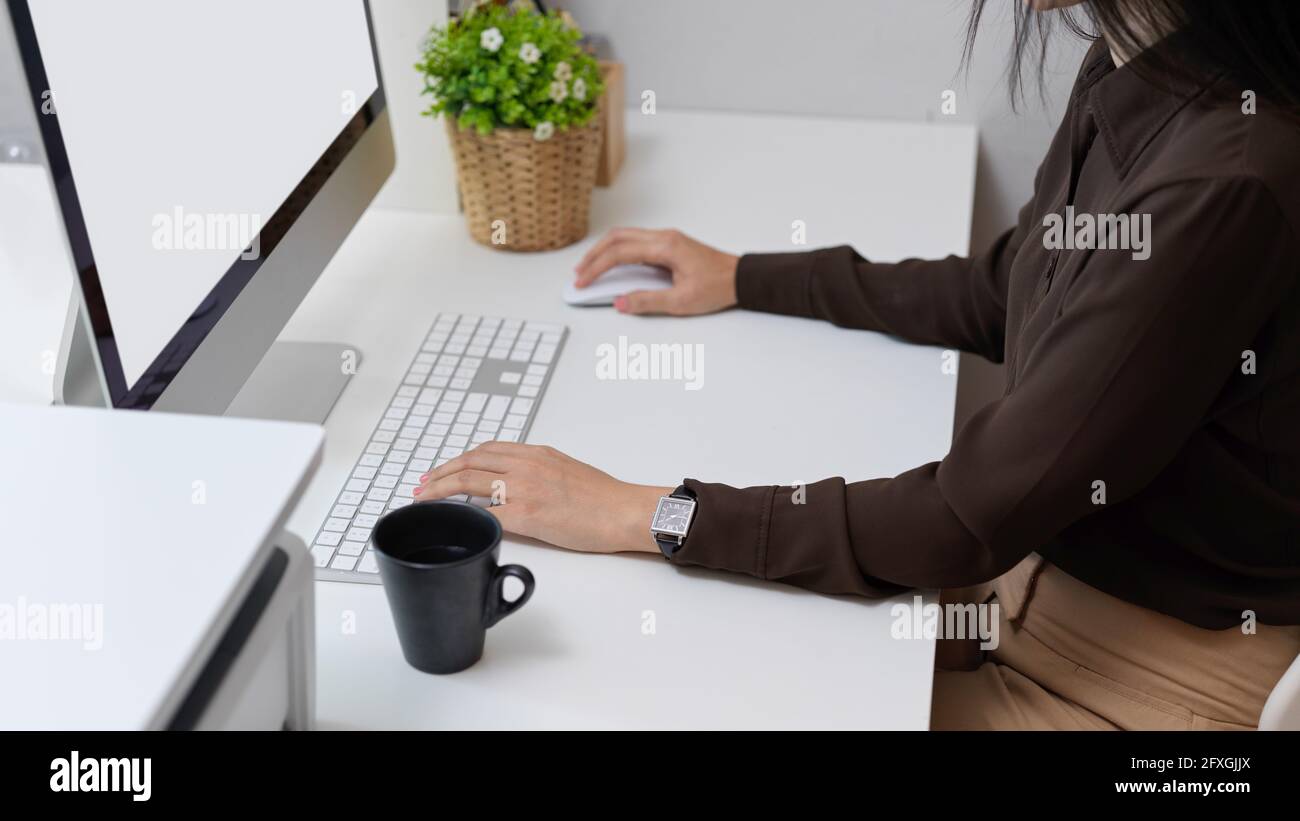 Side view of female office worker hands using computer device on white ...