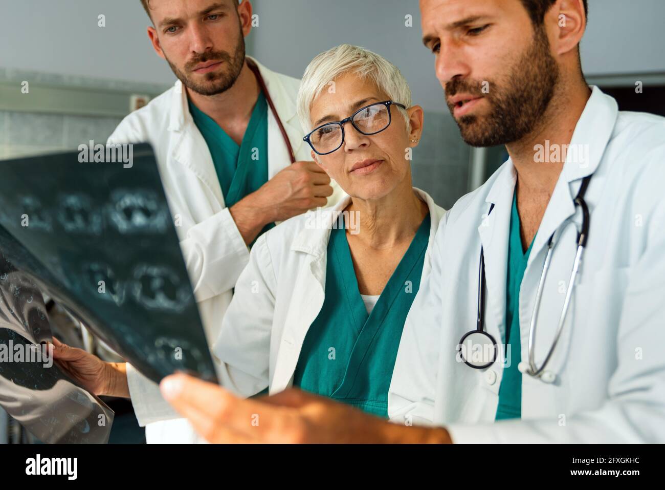 Radiologist doctor consulting with colleagues an x-ray scan in hospital ...
