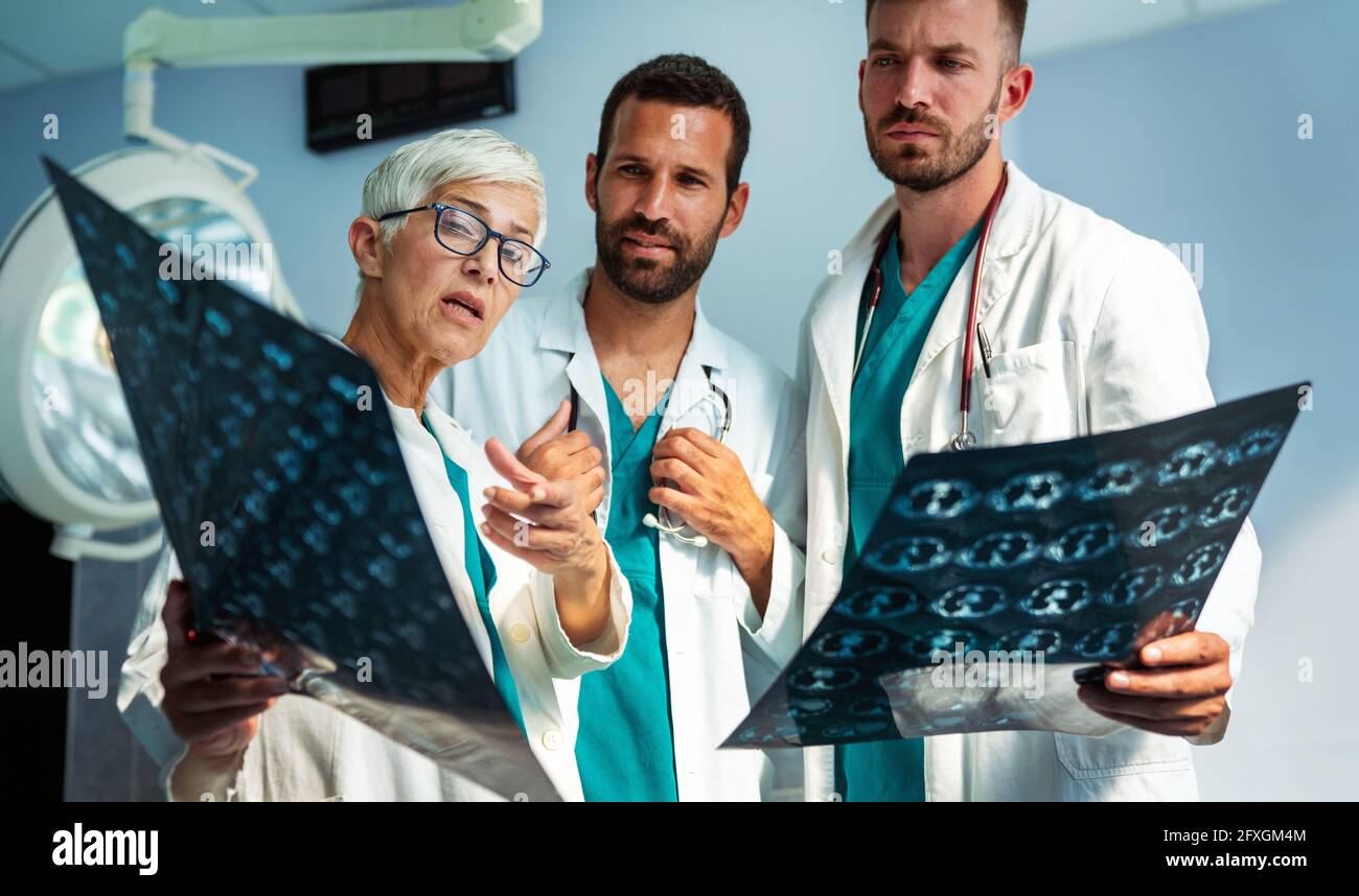 Group of radiology doctor looking at x-ray and discussing it Stock ...