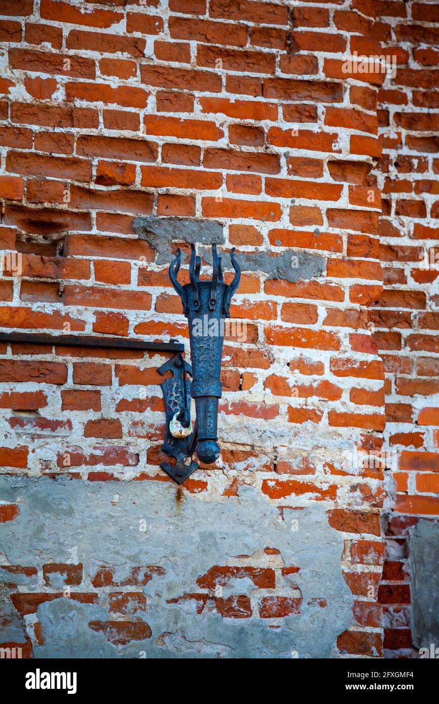 Metal torch stand on an old brick wall. Fragment of the Kolomna Kremlin ...