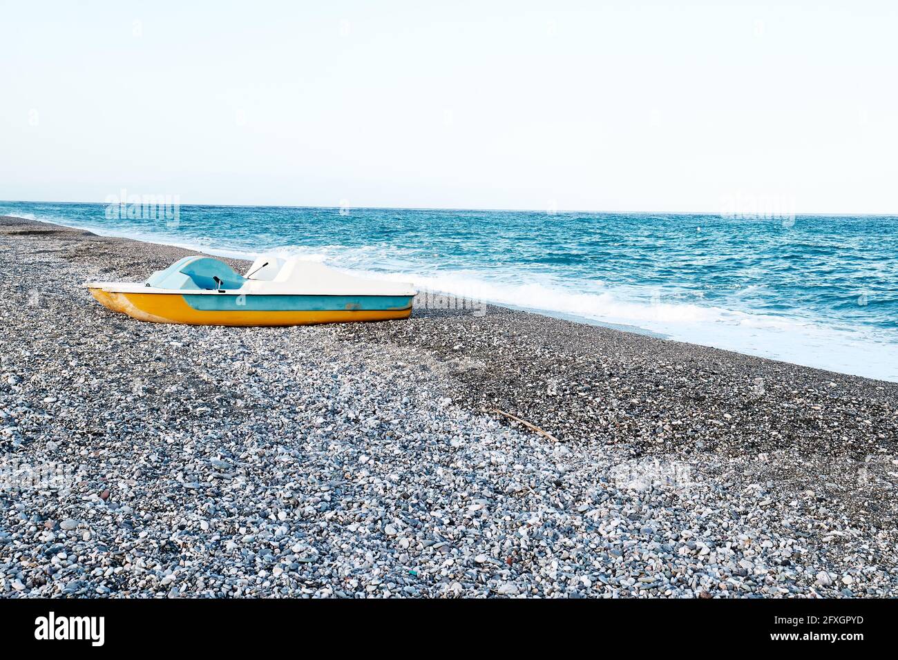 Old Pedal boats on deserted pebble beach in the evening. Sicily as a ...