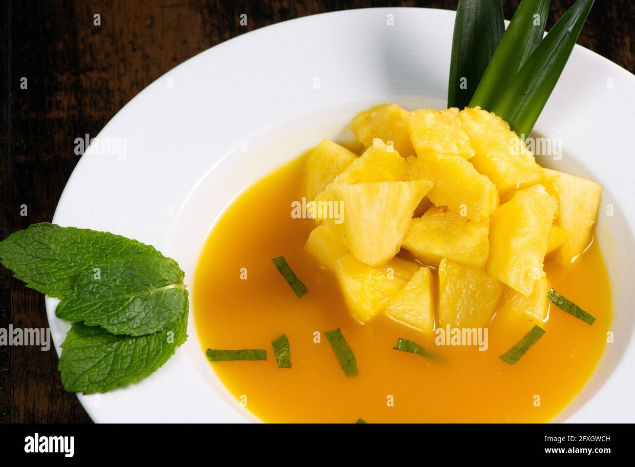 Fresh pineapple dessert recipe with mint orange coulis Stock Photo - Alamy