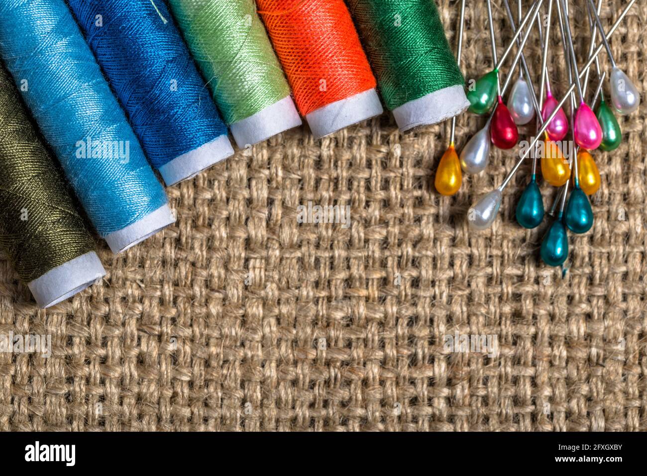 Colorful thread spool for sewing on textile background Stock Photo - Alamy