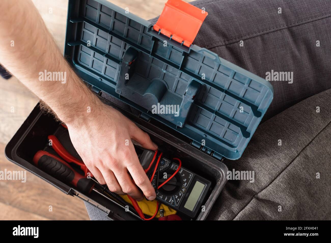 partial view of handyman taking digital multimeter from toolbox Stock ...