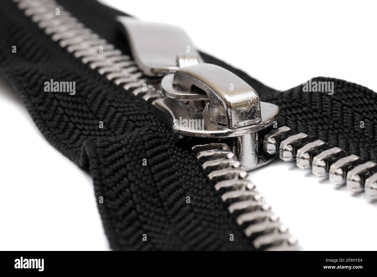 macro of open metal zipper with black fabric isolated on white ...