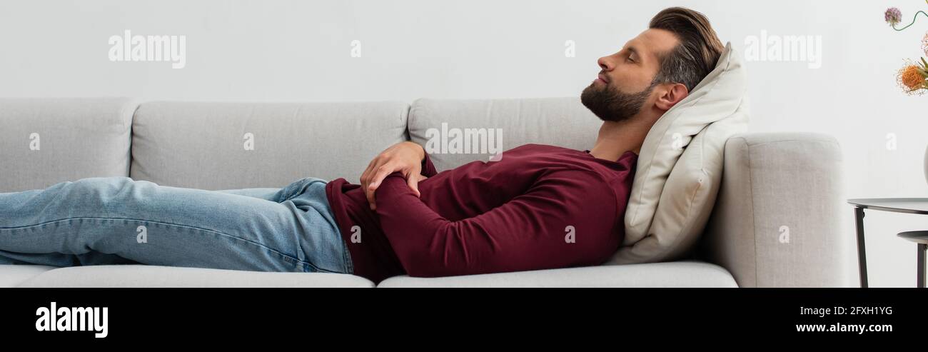 Handsome man sleeping on couch hi-res stock photography and images - Alamy