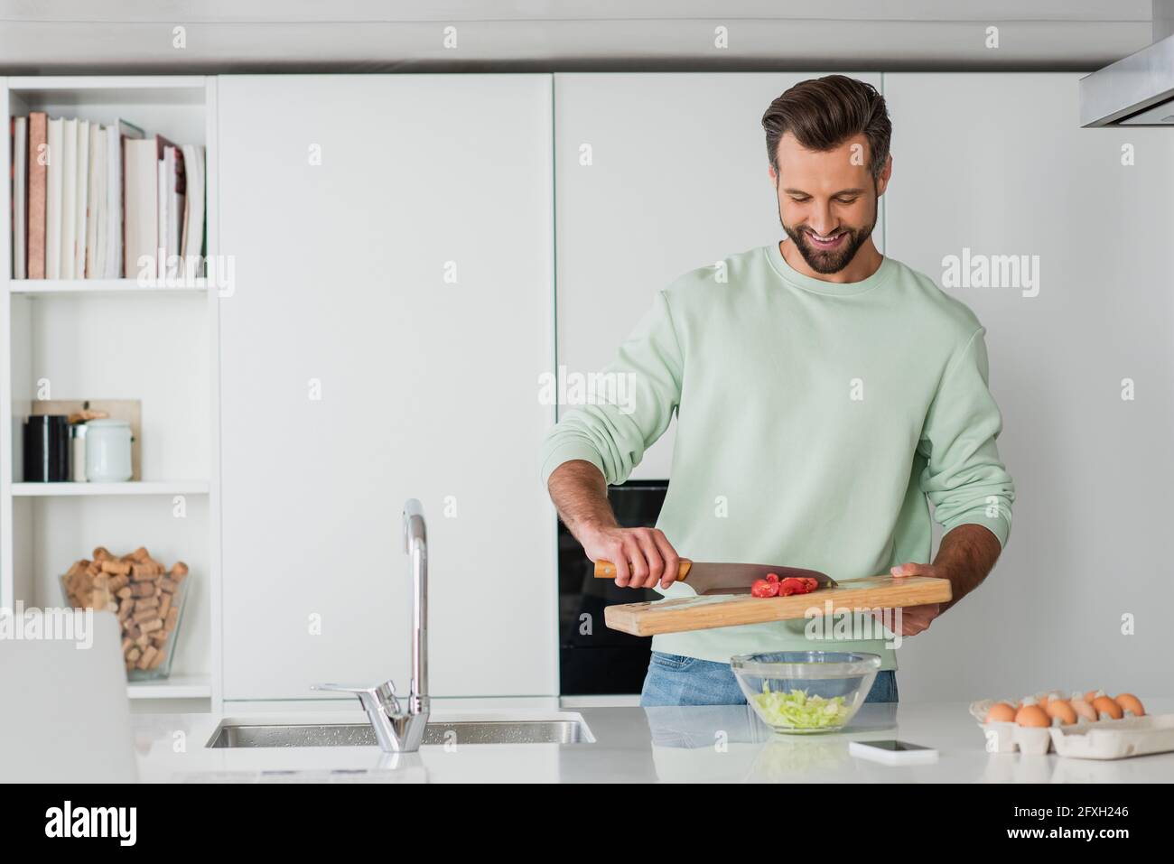 positive man smiling while cooking breakfast in kitchen Stock Photo - Alamy