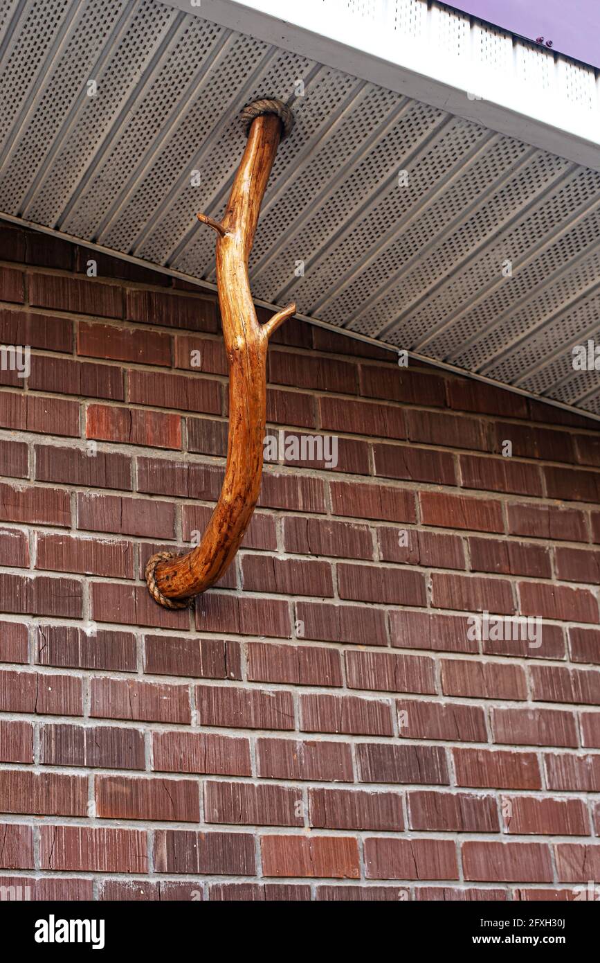 Decorative tree branch support on brick building wall Stock Photo - Alamy
