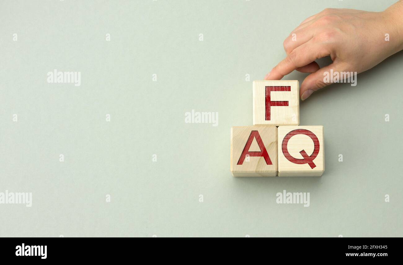 inscription FAQ (frequently asked questions) on wooden blocks on a gray ...