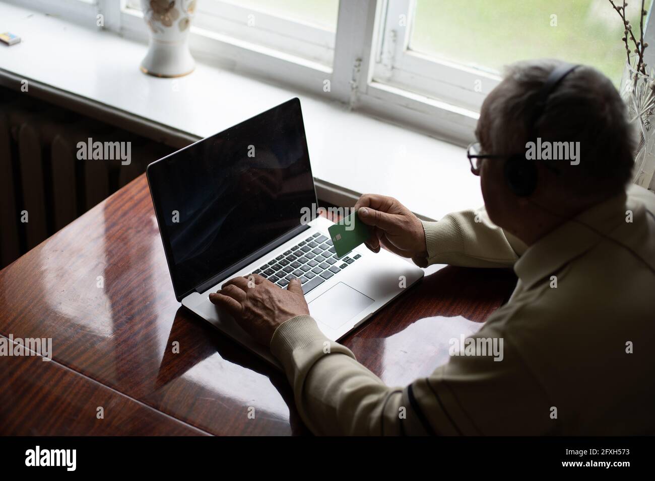 Elderly man with glasses using laptop at home Stock Photo - Alamy