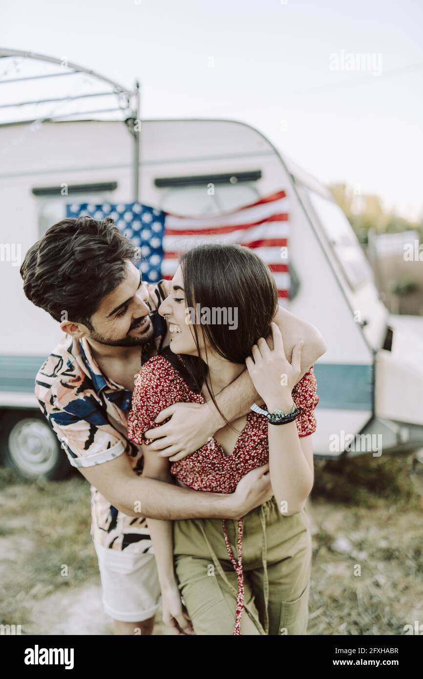 A beautiful Spanish couple hugging on background of the US flag - US ...