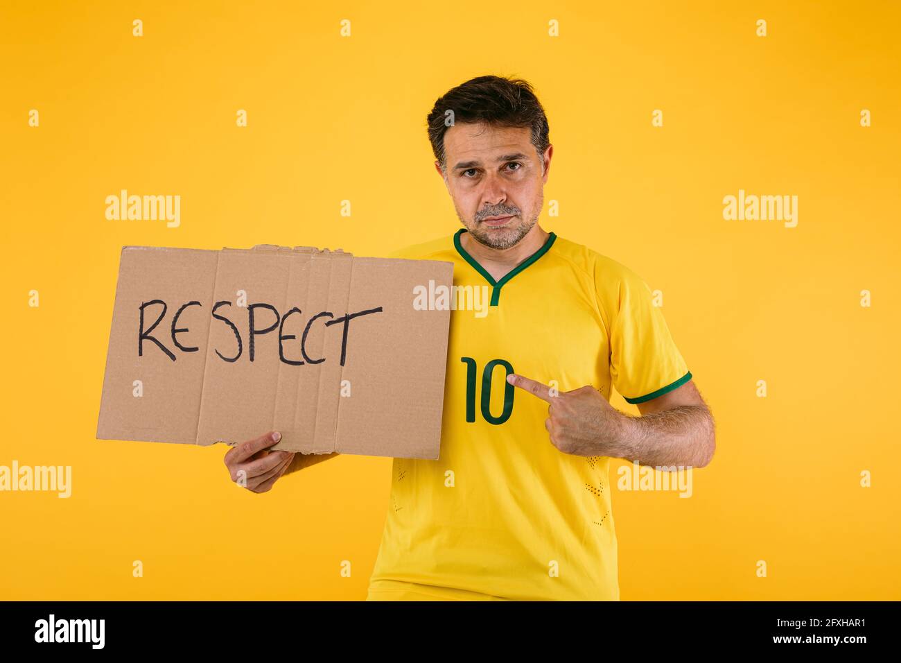 Brazilian Soccer fan with yellow shirt and a sign that says 'Respect ...