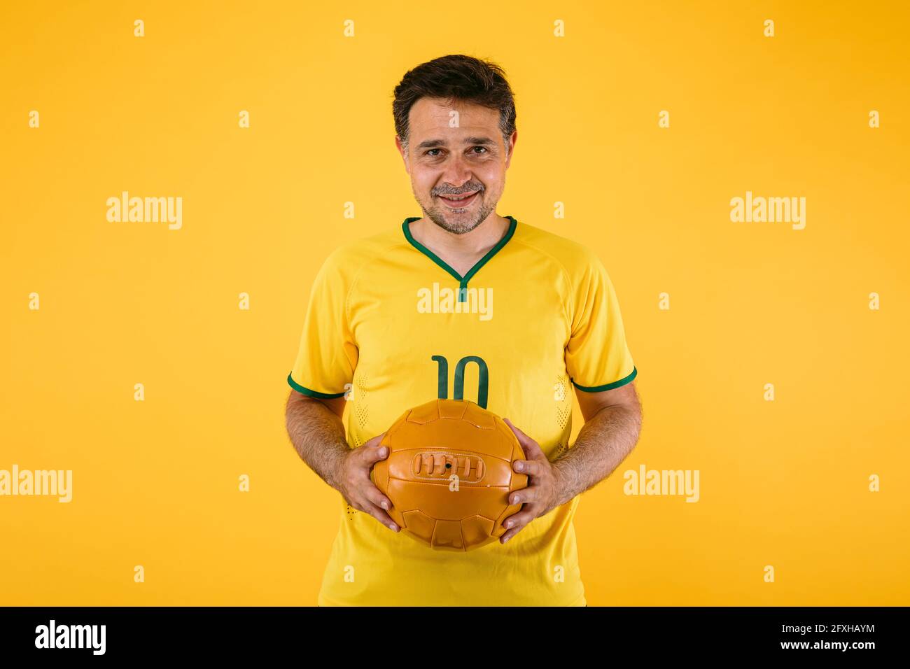Brazilian soccer fan with red jersey and a retro ball in his hands ...