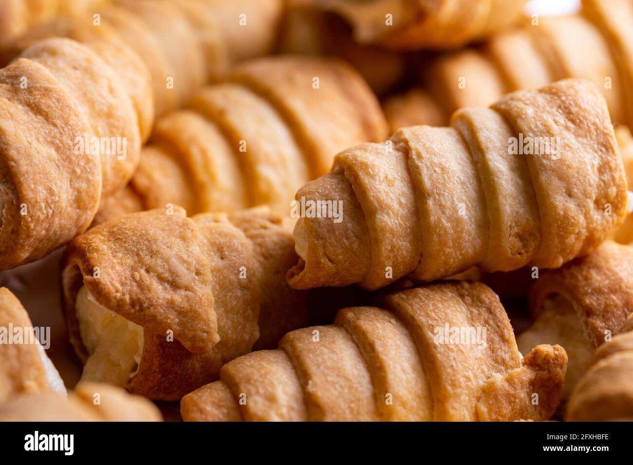 Lots of sweet home made pastry tubes with cream. Photo taken under soft ...