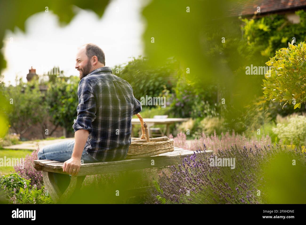 Happy man taking. break from gardening on bench in summer garden Stock ...