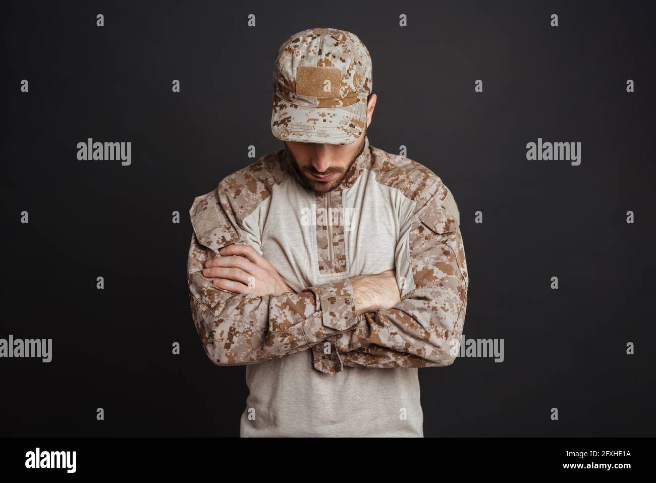 Close up of a handsome pensive young military man in uniform thinking ...