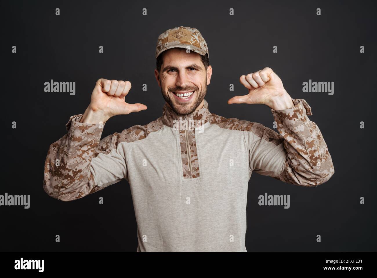 Happy military man celebrating success isolated over black wall ...