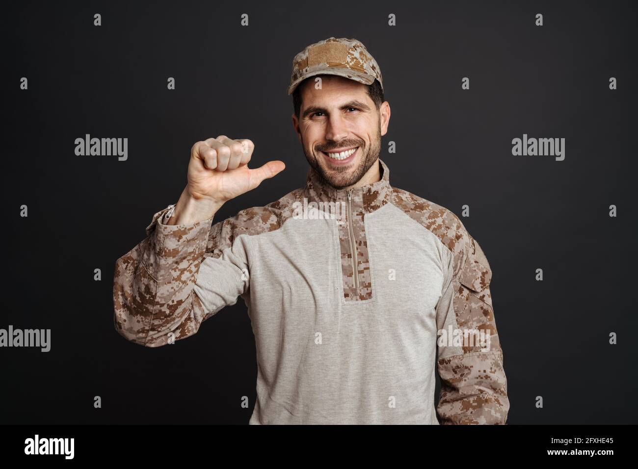 Happy military man celebrating success isolated over black wall ...