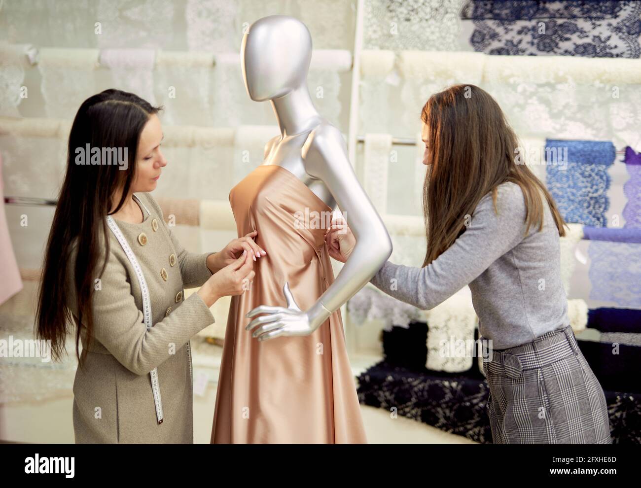 Professional brunette team of tailors, dressmakers or designers working ...