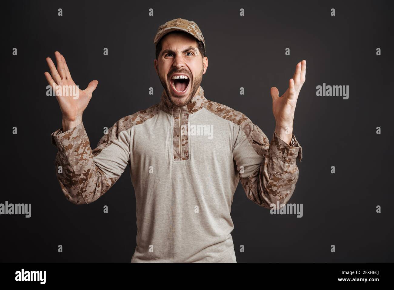 Furious masculine military man screaming with his hands up isolated ...