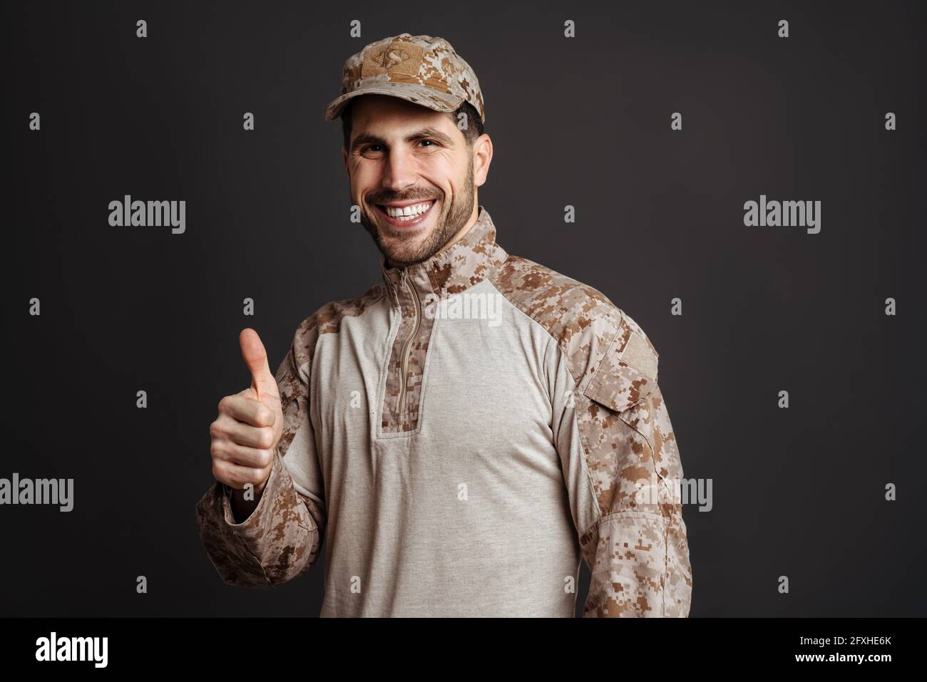 Happy masculine military man smiling and showing thumb up isolated over ...