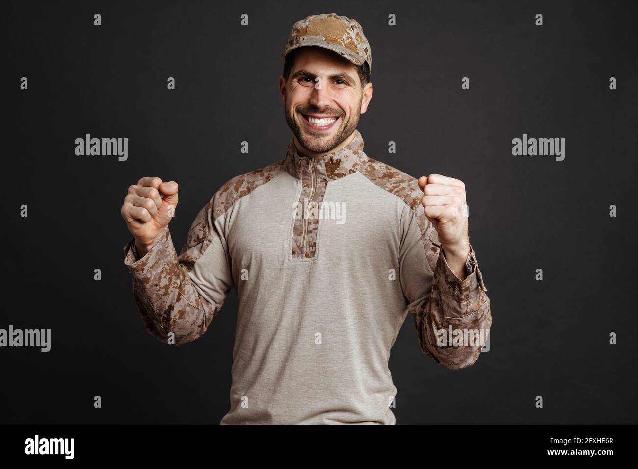 Excited masculine military man smiling and making winner gesture ...