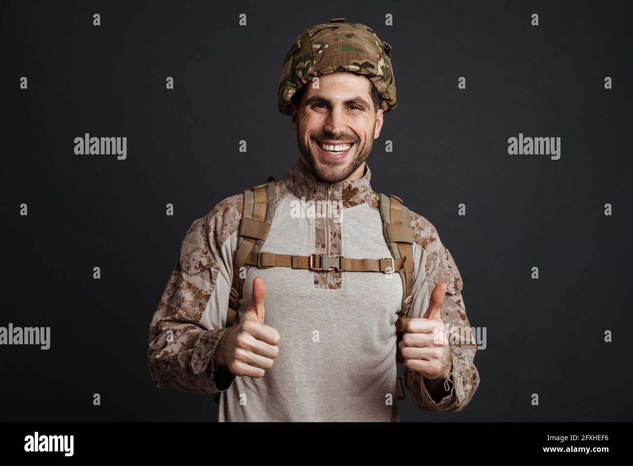 Happy military man wearing helmet smiling and showing thumb up isolated ...