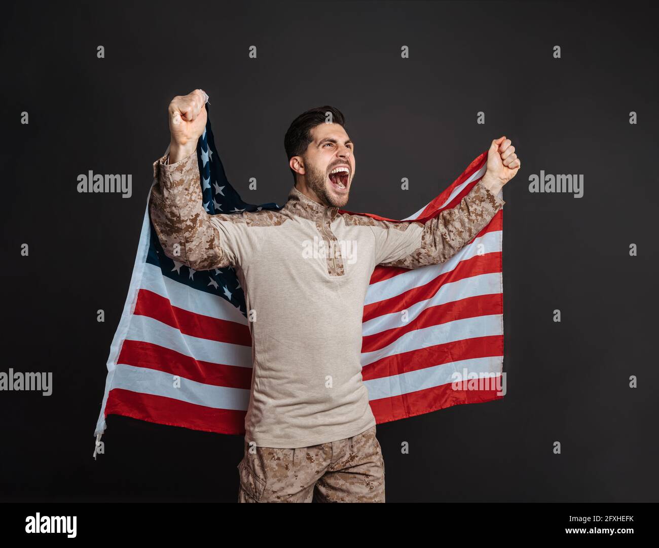 Excited military man screaming while posing with american flag isolated ...