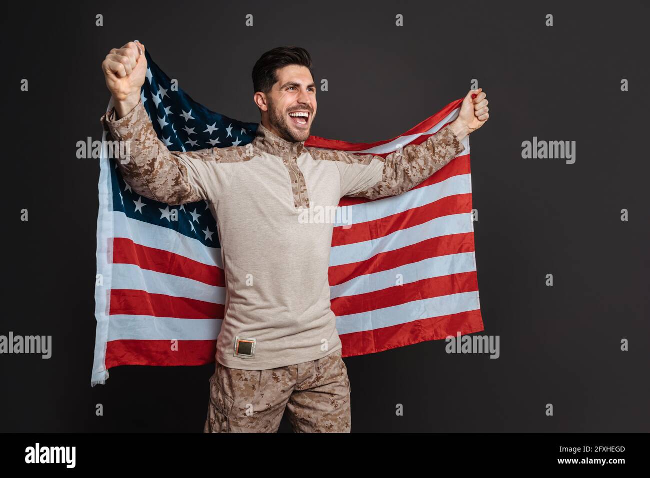 Happy masculine military man smiling while posing with american flag ...