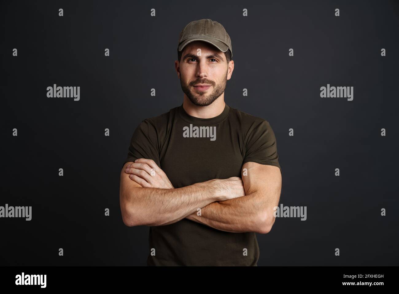 Pleased masculine military man posing with arms crossed isolated over ...