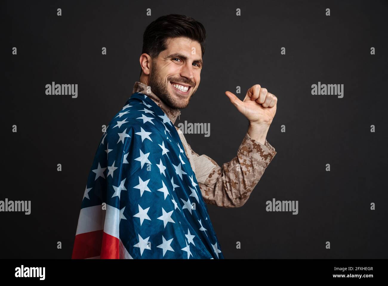 Happy masculine military man with american flag pointing finger aside ...