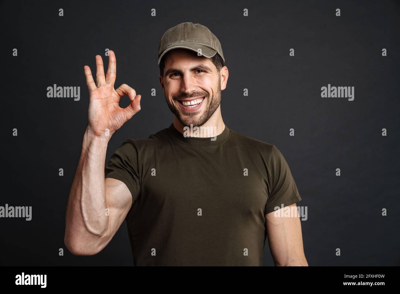 Happy masculine military man smiling and showing ok sign isolated over ...