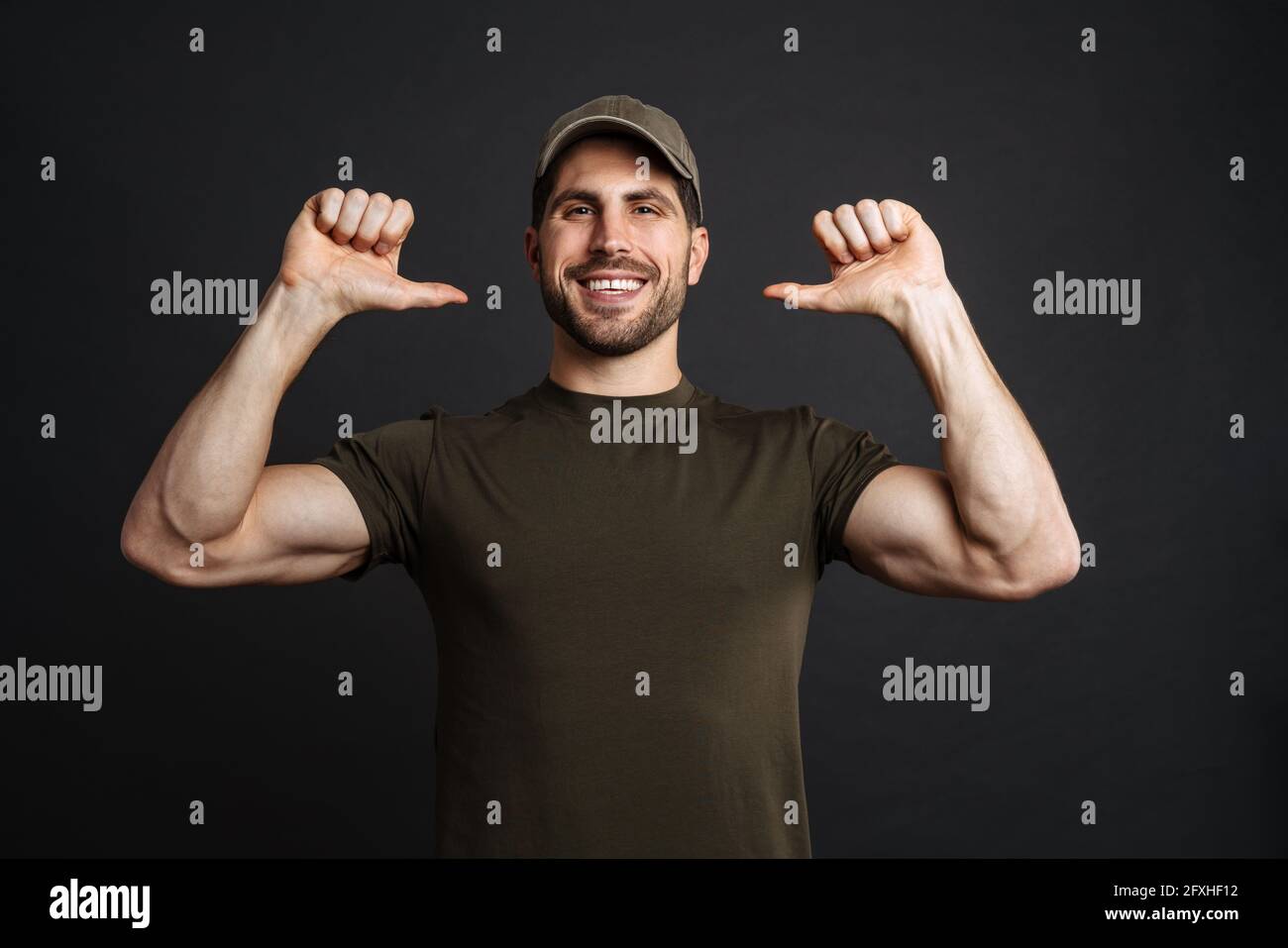 Happy military man celebrating success isolated over black wall ...
