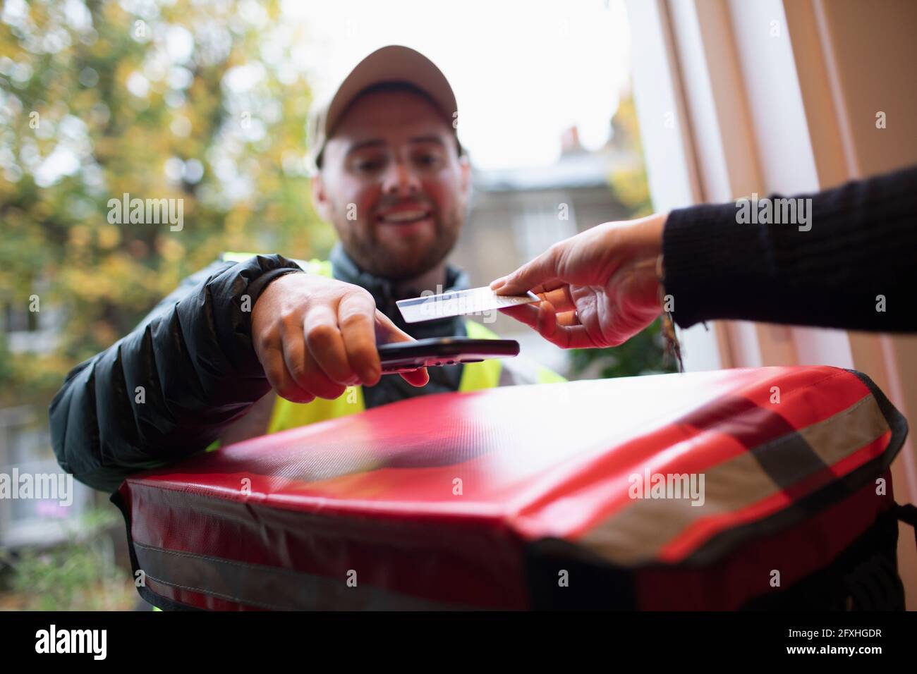 Customer paying delivery man with contactless card at front door Stock ...