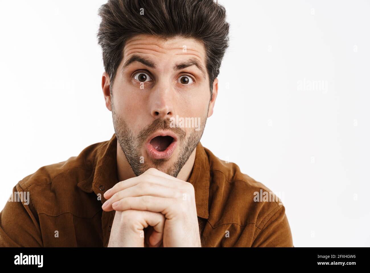 Excited handsome young man expressing surprise on camera isolated over ...