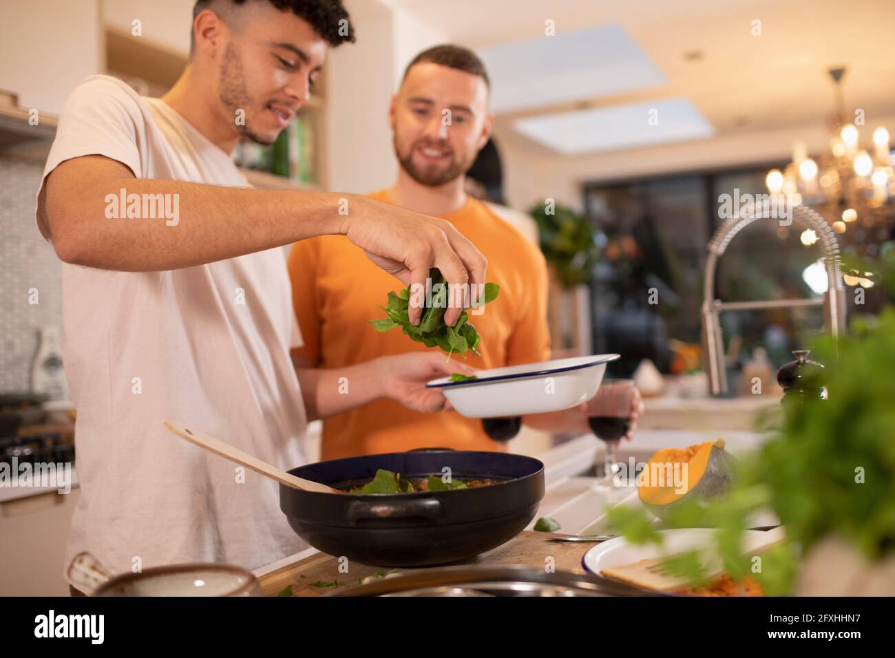 Homosexual Couple Cooking Food In Kitchen High Resolution Stock ...