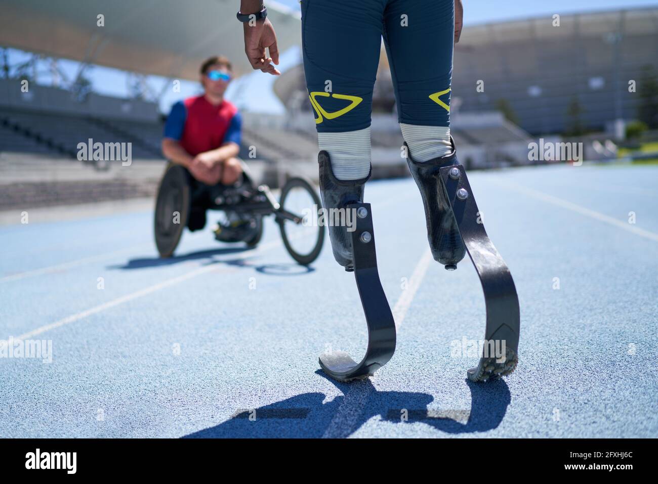 Male amputee and wheelchair athletes on sunny blue sports track Stock ...