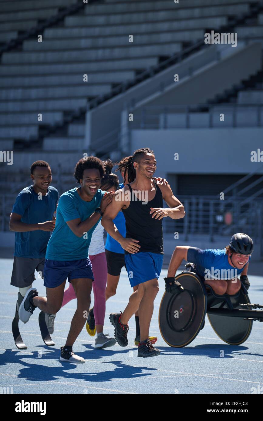 Happy athletes on sunny sports track Stock Photo - Alamy