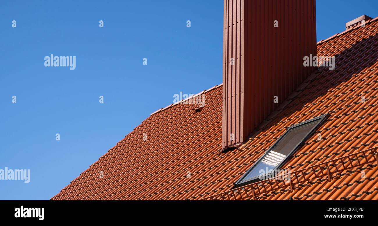 Red corrugated metal profile roof installed on a modern house. The roof ...