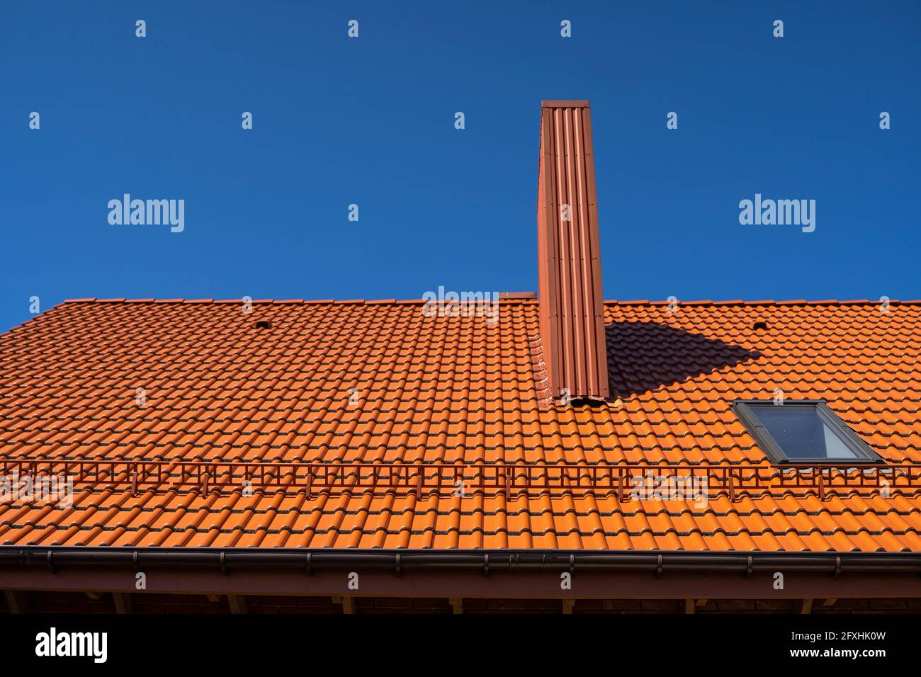 Red corrugated metal profile roof installed on a modern house. The roof ...