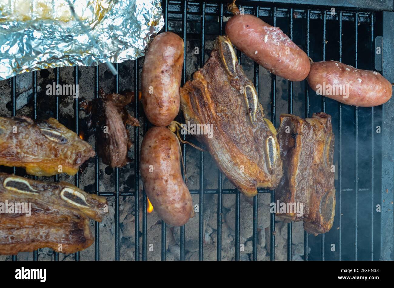 Top view of traditional Argentinian Asado, sausages, and meat cooking ...
